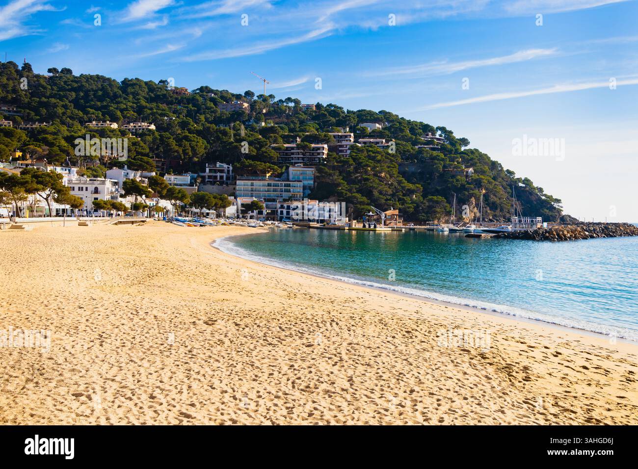 Sunny Llafranc beach with golden sand, calm turquoise sea, and white ...