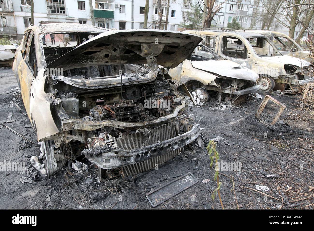 Destroyed cars are seen outside a multi-storey residential block ...
