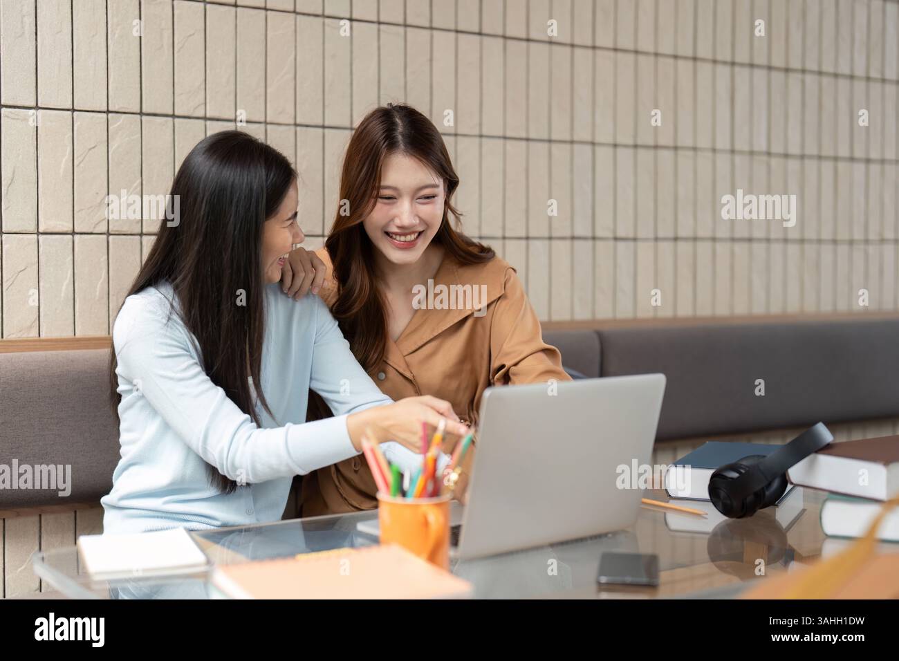 Teamwork and Learning. Two friends sharing laughter and knowledge while ...