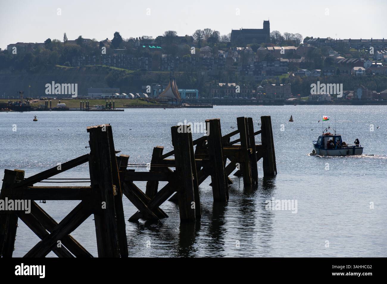 A boat flying the Welsh Dragon Flag, heads for Penarth Head,Cardiff Bay ...