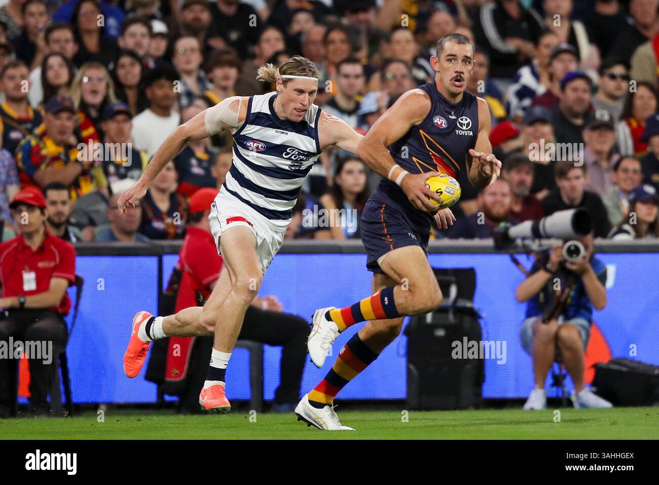 Taylor Walker of the Crows evades Mark Blicavs of the Cats during the ...