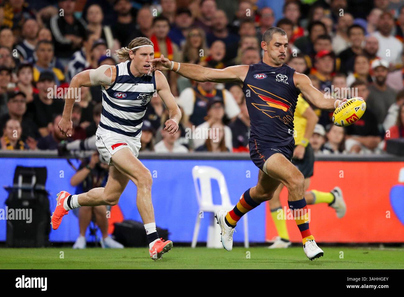 Taylor Walker of the Crows evades Mark Blicavs of the Cats during the ...