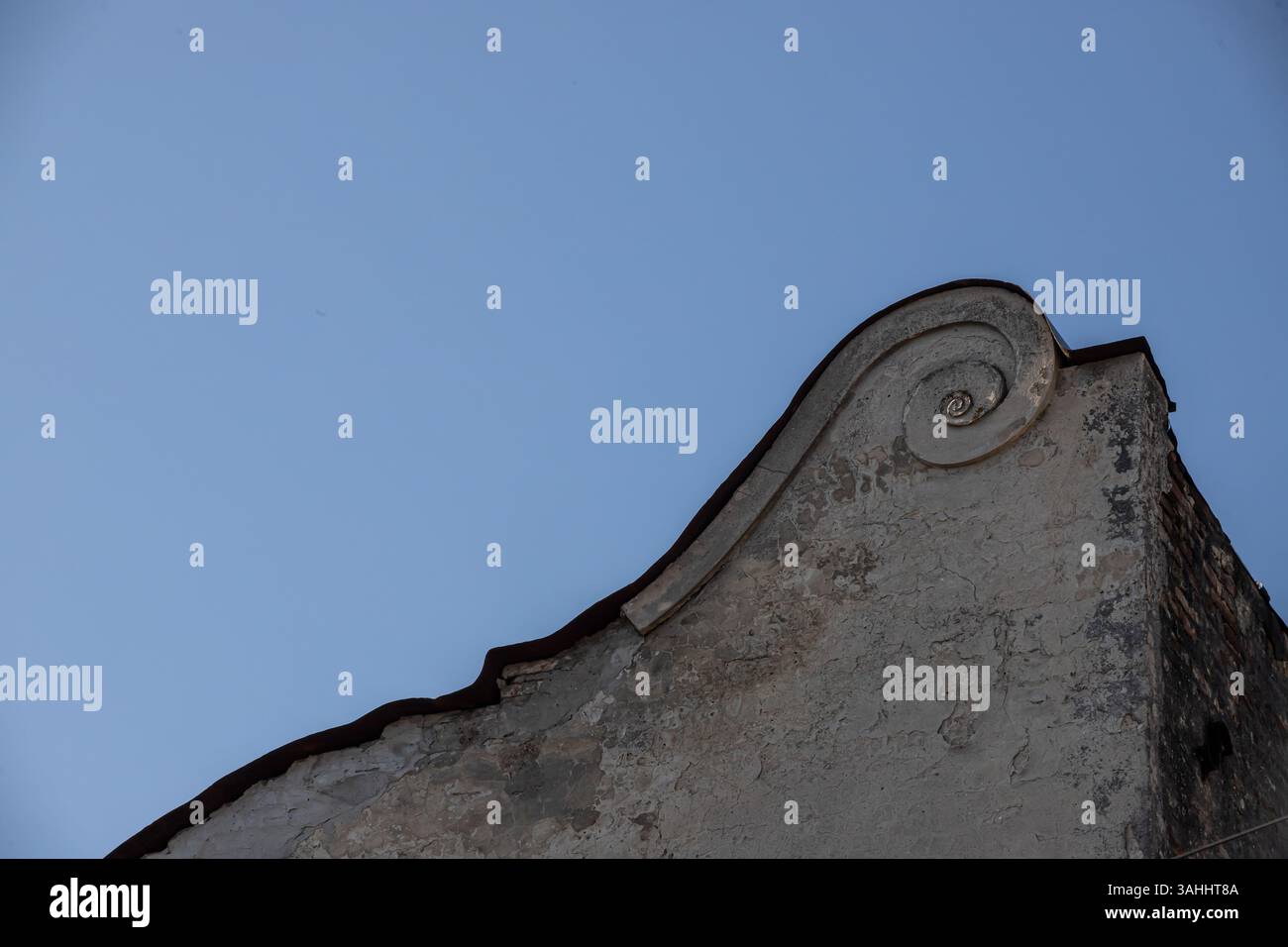 An ornate architectural edge rises against an unclouded blue sky ...