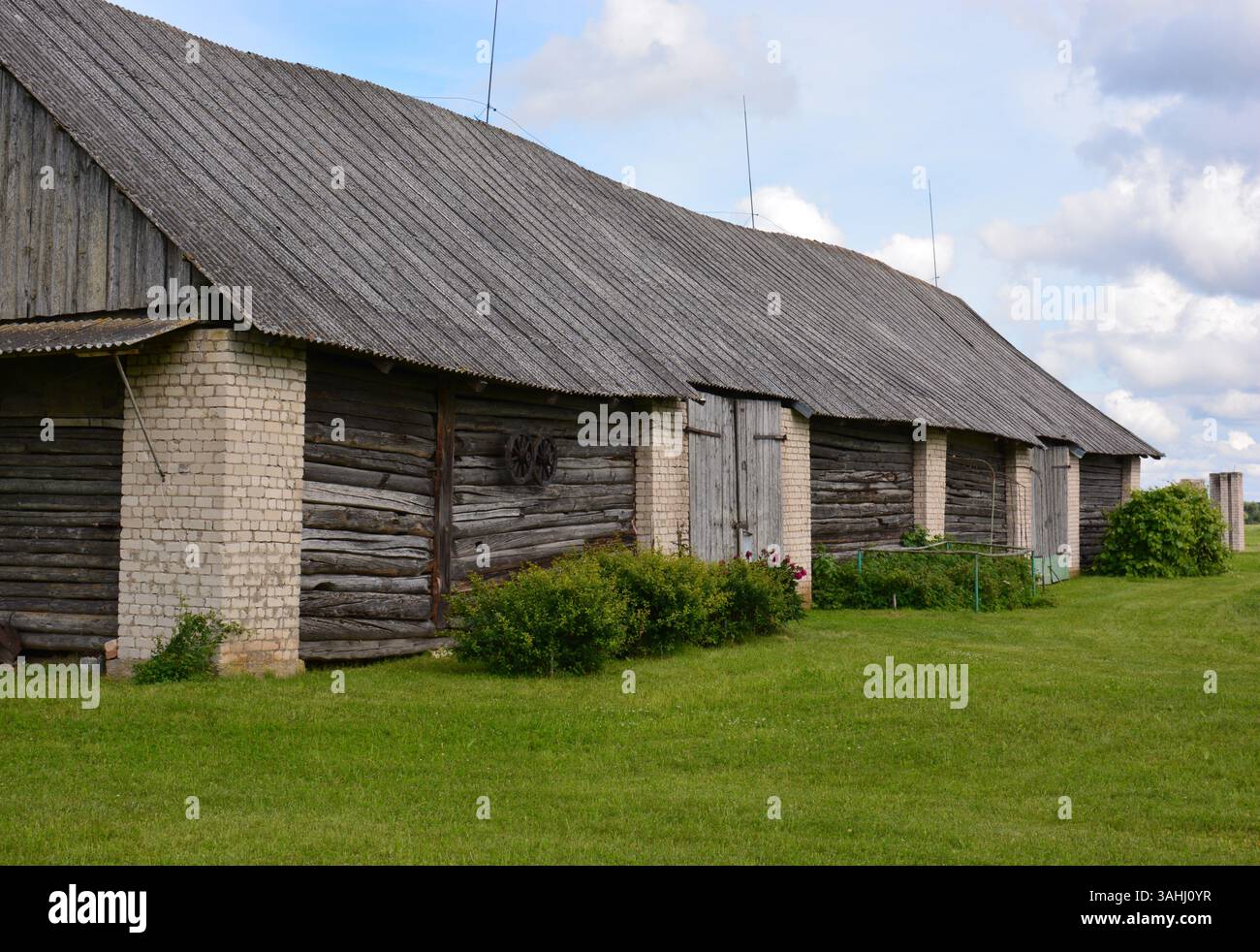 Old barn for hay storage with slate-covered roof, brick columns and ...