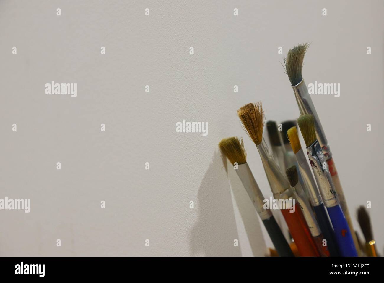 Colorful brushes stand upright on a work surface, their bristles ...
