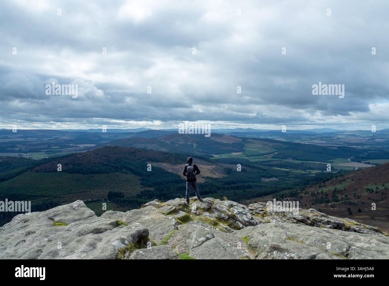 A hiker stands atop Mither Tap in the Bennachie Hills in Scotland ...