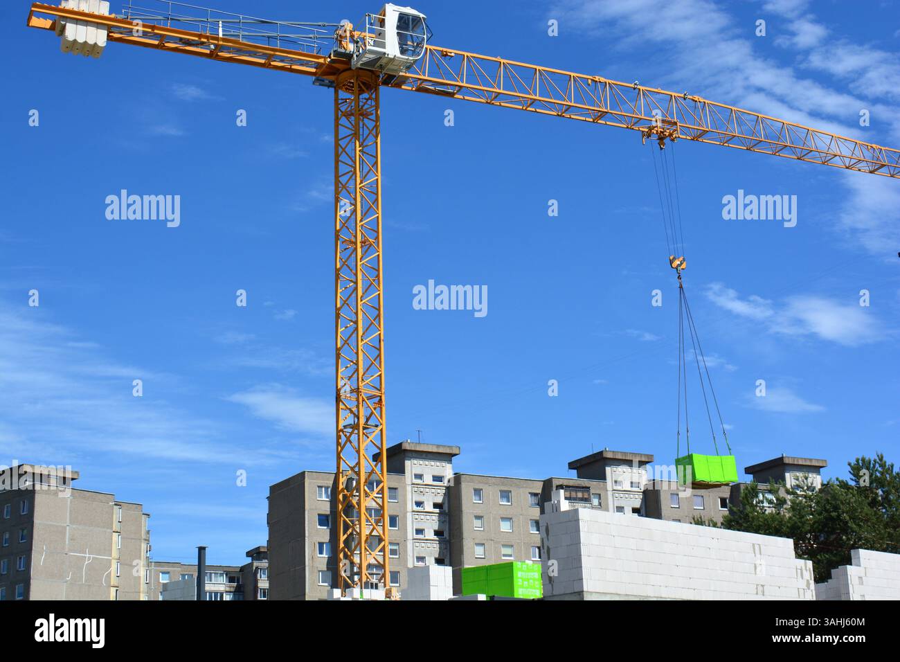Big construction crane working in construction site lifting heavy loads ...