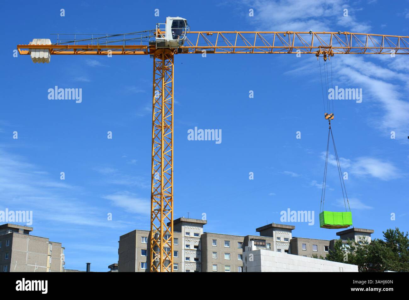 Big construction crane working in construction site lifting heavy loads ...