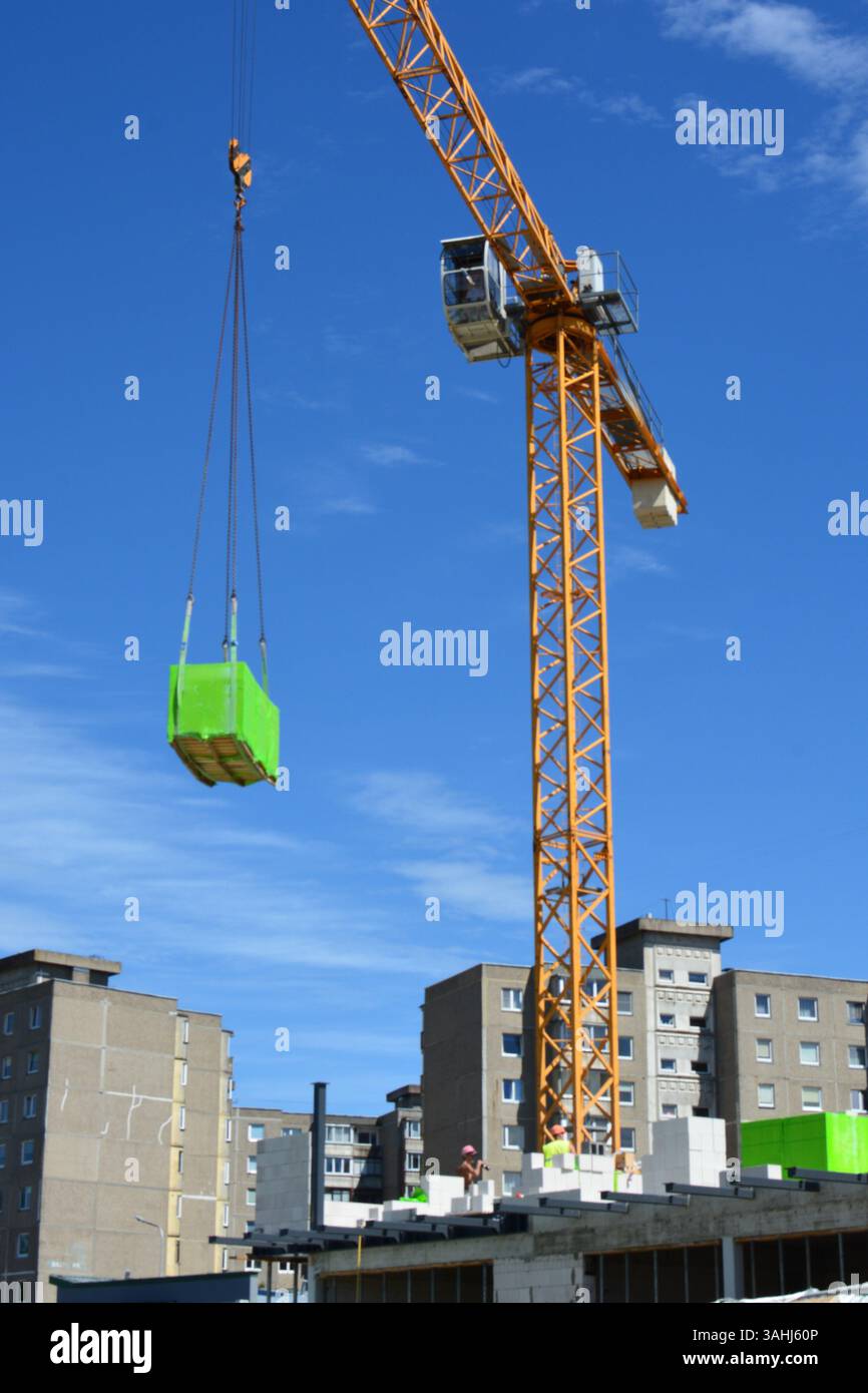 Big construction crane working in construction site lifting heavy loads ...
