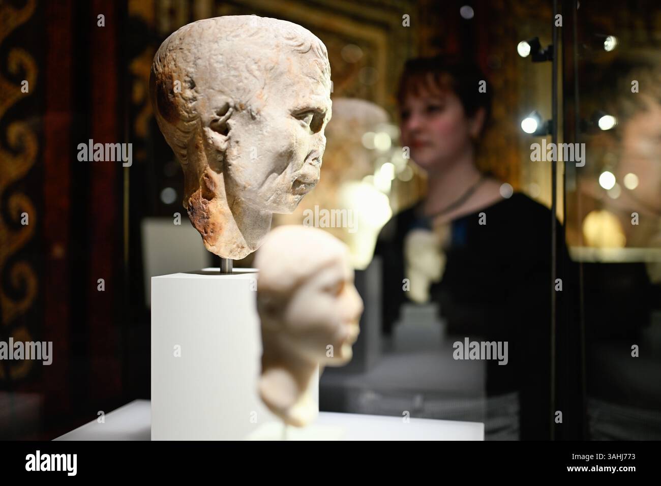Speyer, Germany. 10th Apr, 2025. A woman stands behind portraits of the ...