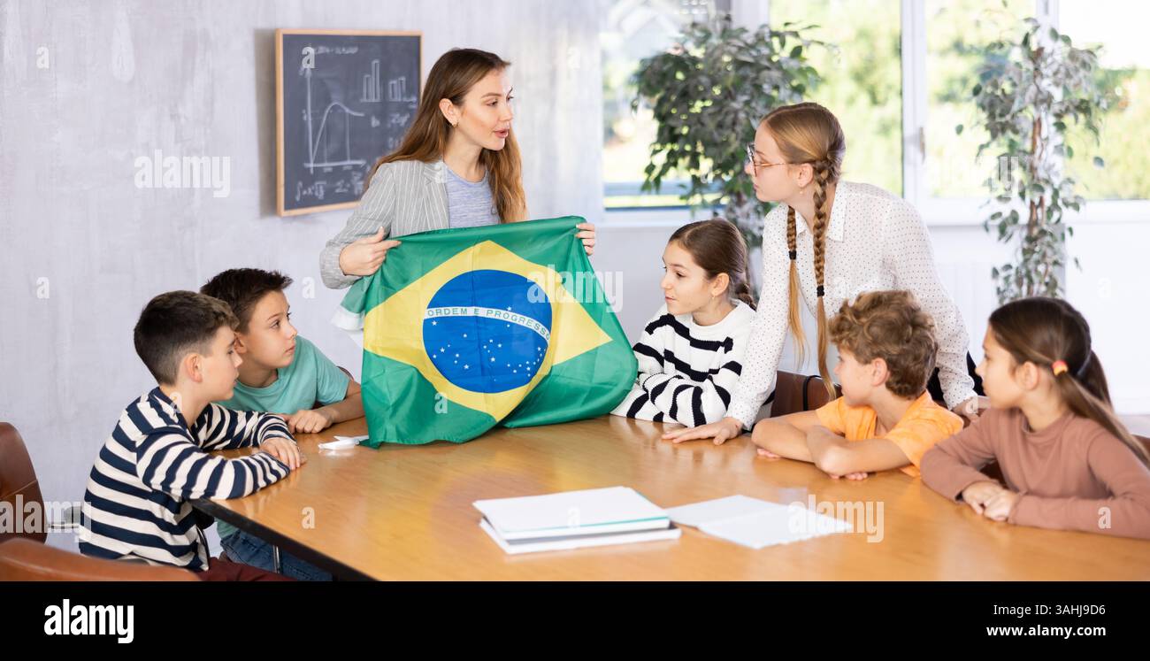 Teacher showing Brazil flag to group of schoolchildren Stock Photo - Alamy