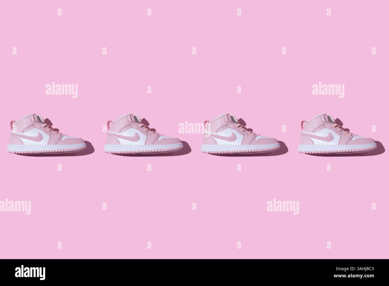 Pattern of pink Air Jordan 1 Mid sneakers, in a row, on a pink ...