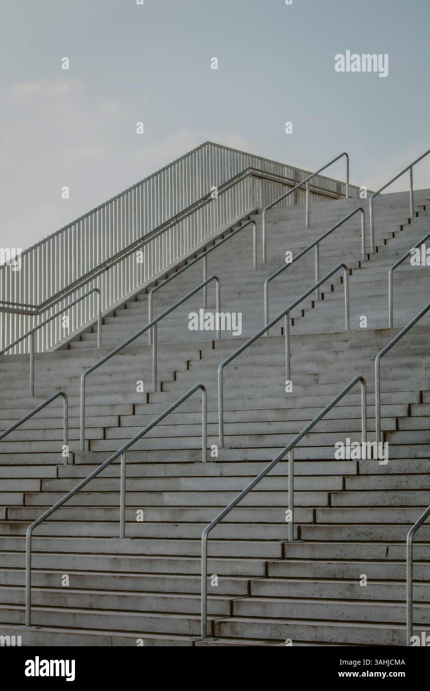 Concrete steps with metal railings against a clear sky, leading upward ...