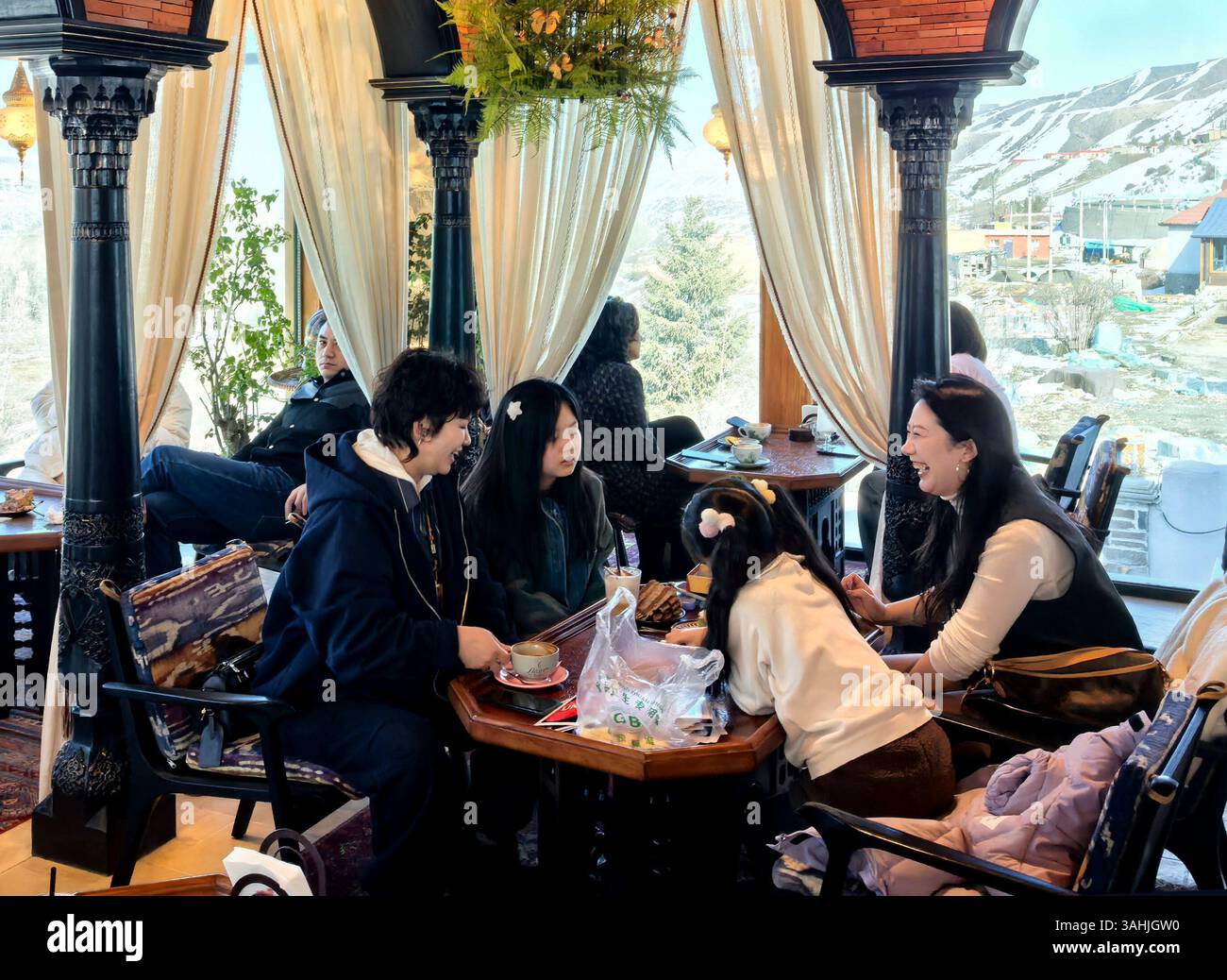 (250410) -- URUMQI, April 10, 2025 (Xinhua) -- Customers enjoy coffee ...