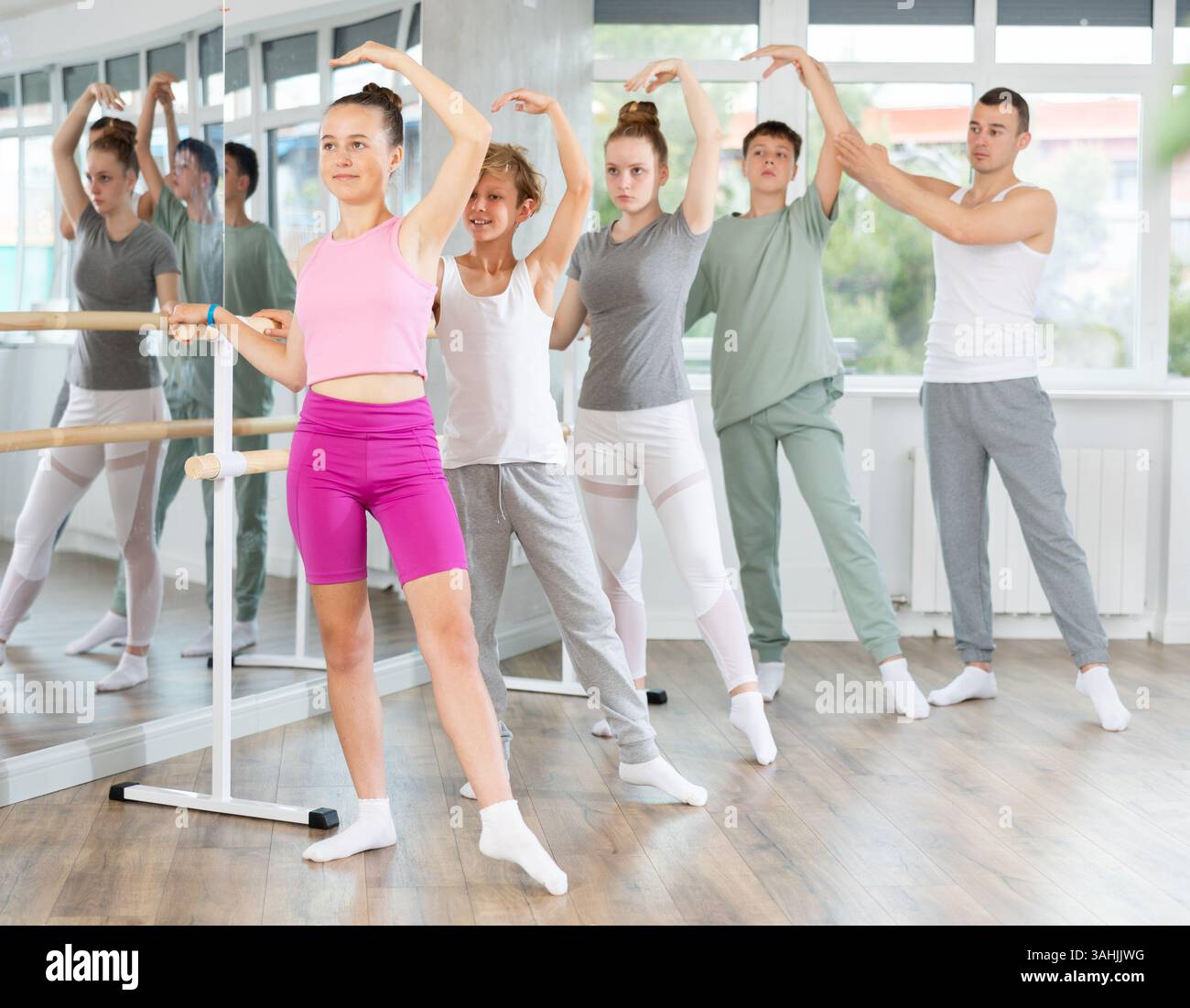 Teacher conducts class with teen girls and boys in ballet studio ...