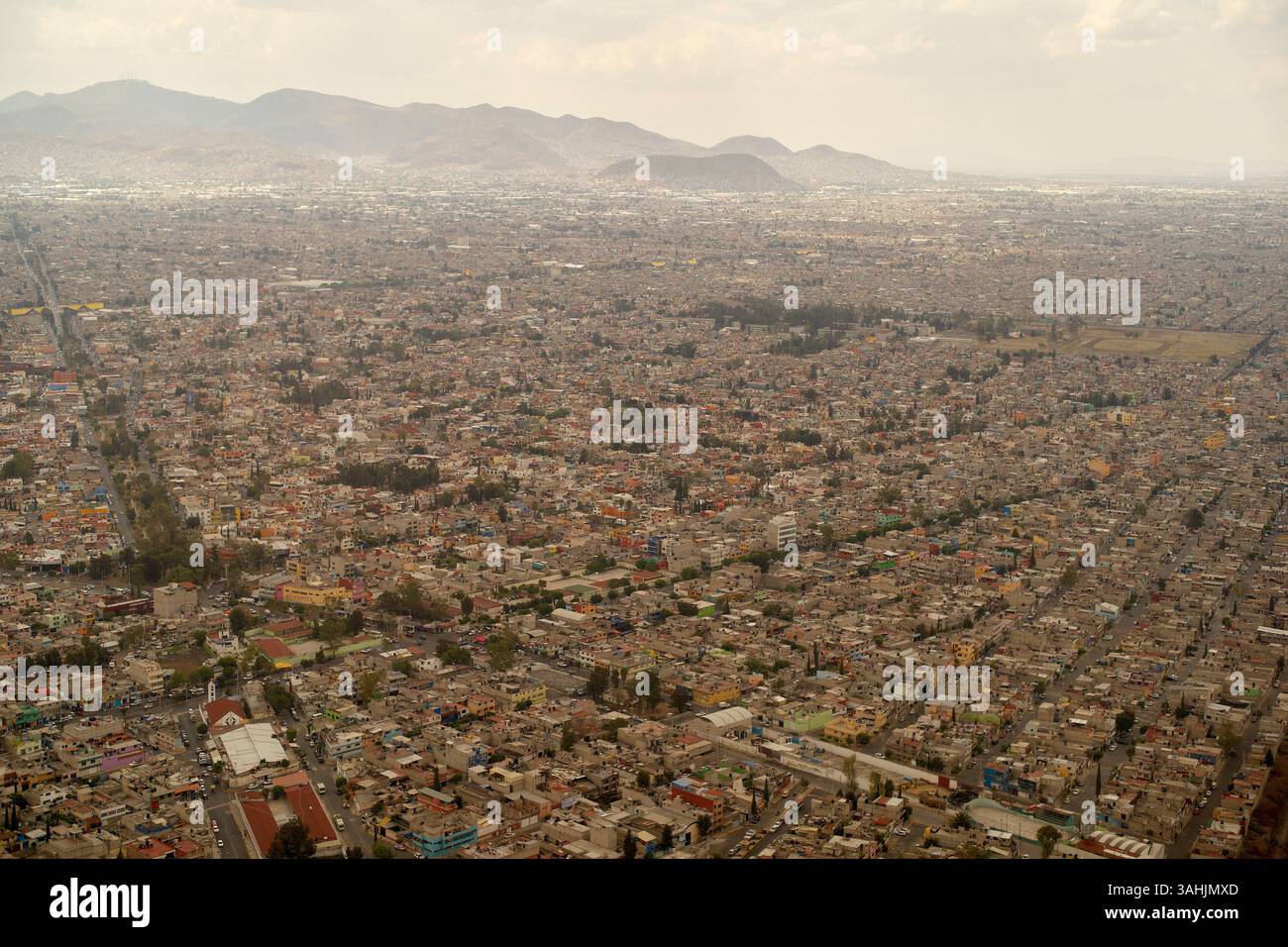 Aerial view of a sprawling cityscape with mountains in the background ...