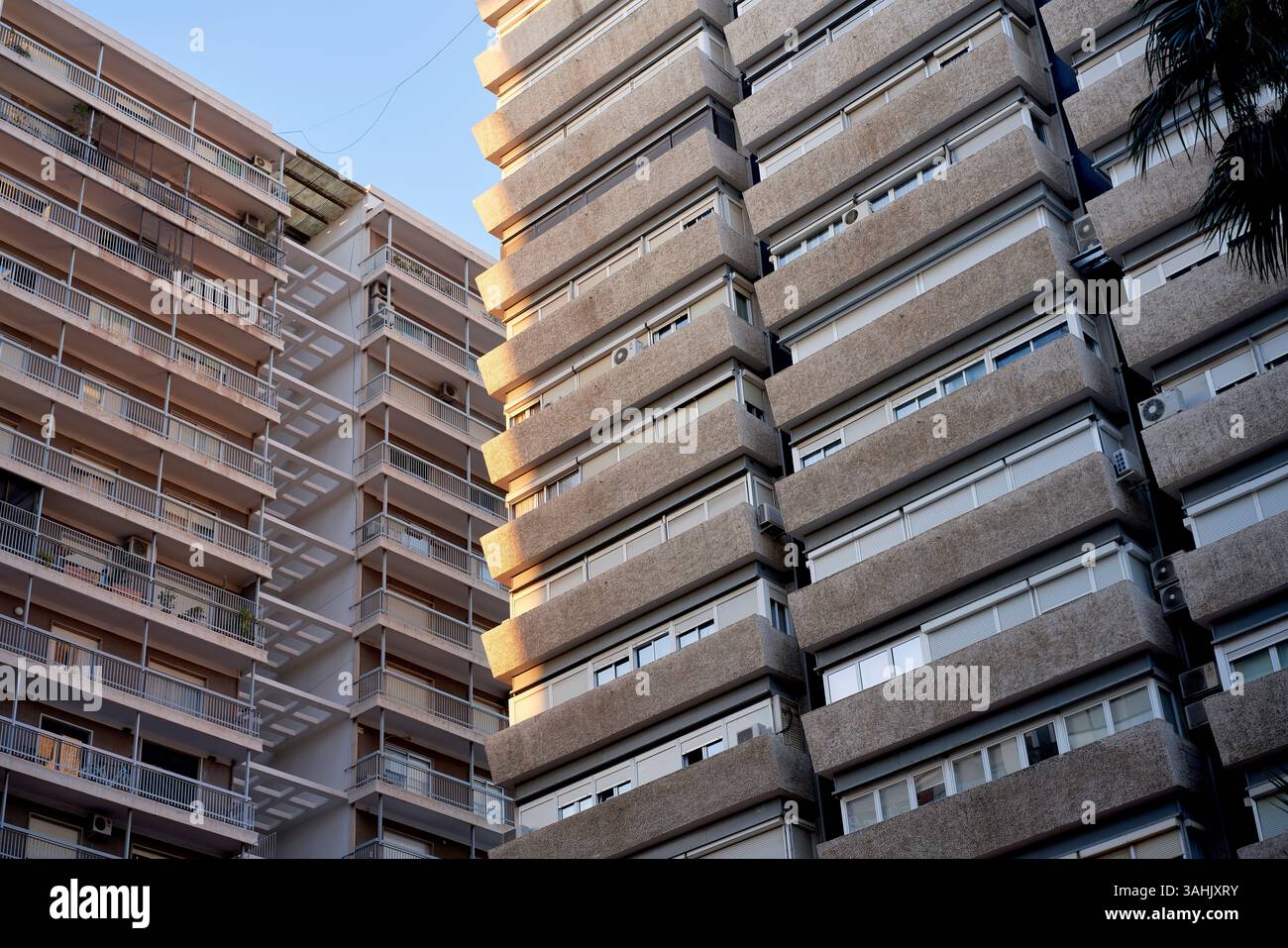 High-rise apartment buildings with balconies under a clear blue sky at ...