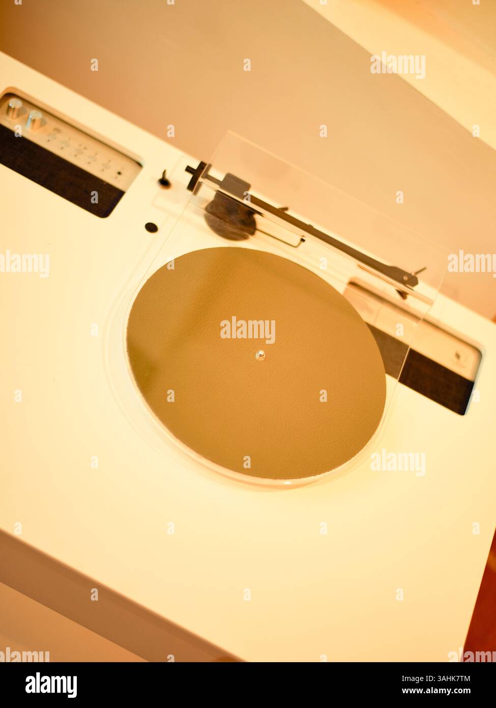 Vintage turntable with a minimalist design and golden platter in warm ...