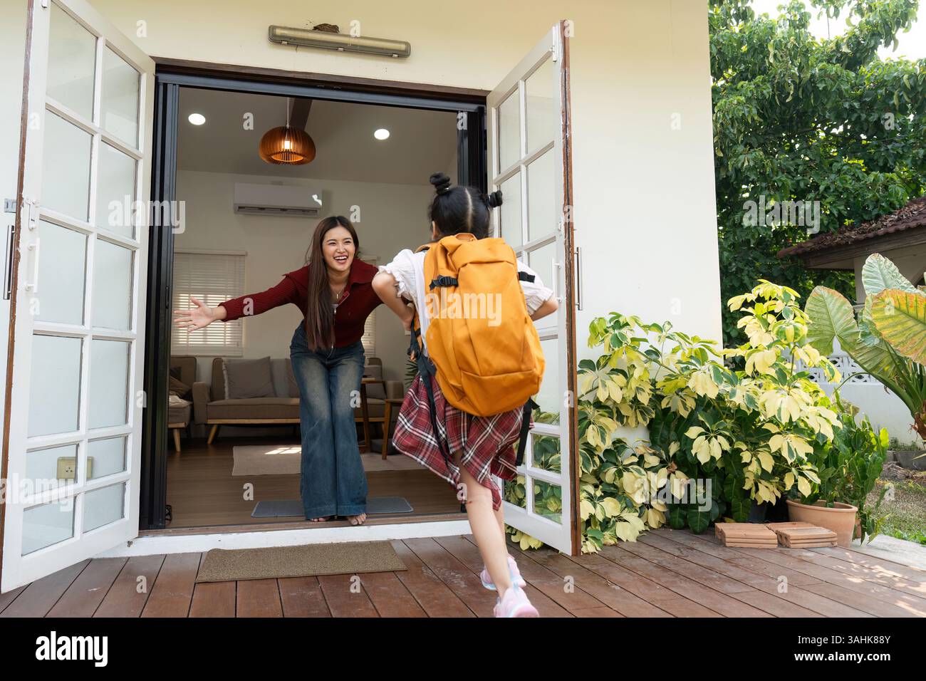 Back to School: A Warm Welcome. A child runs towards her mother, who ...