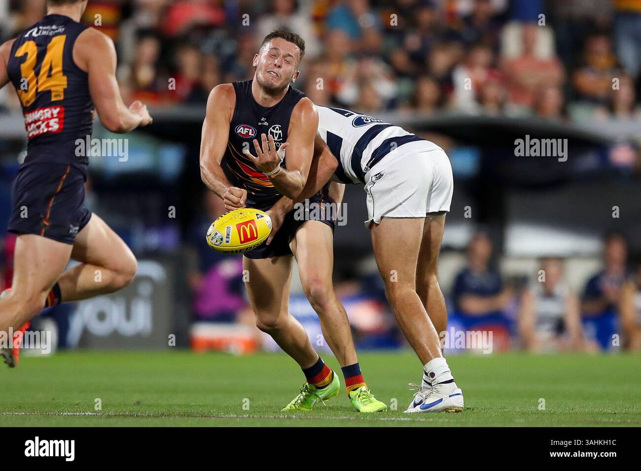 Jake Soligo of the Crows is tackled by Jack Bowes of the Cats during ...