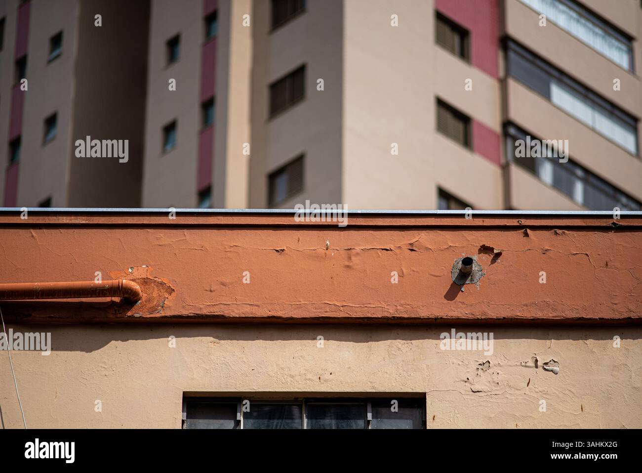 Weathered urban building façade with peeling paint and drainpipe ...