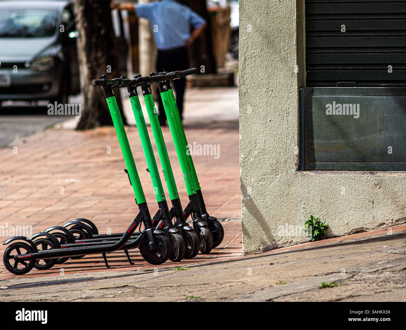 A row of bright green electric scooters parked neatly on a city ...