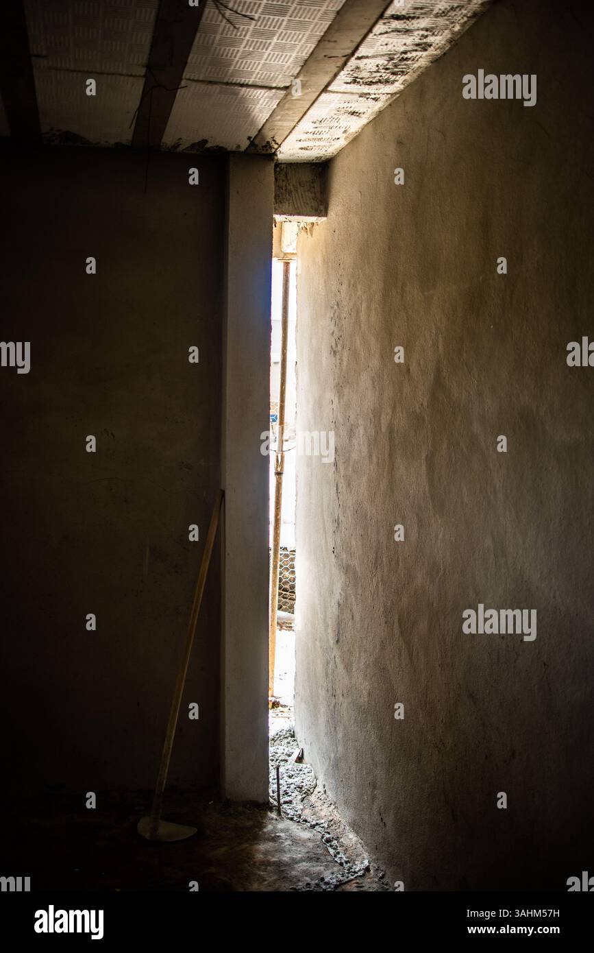 vertical slit on a wall in a construction with some light coming in ...