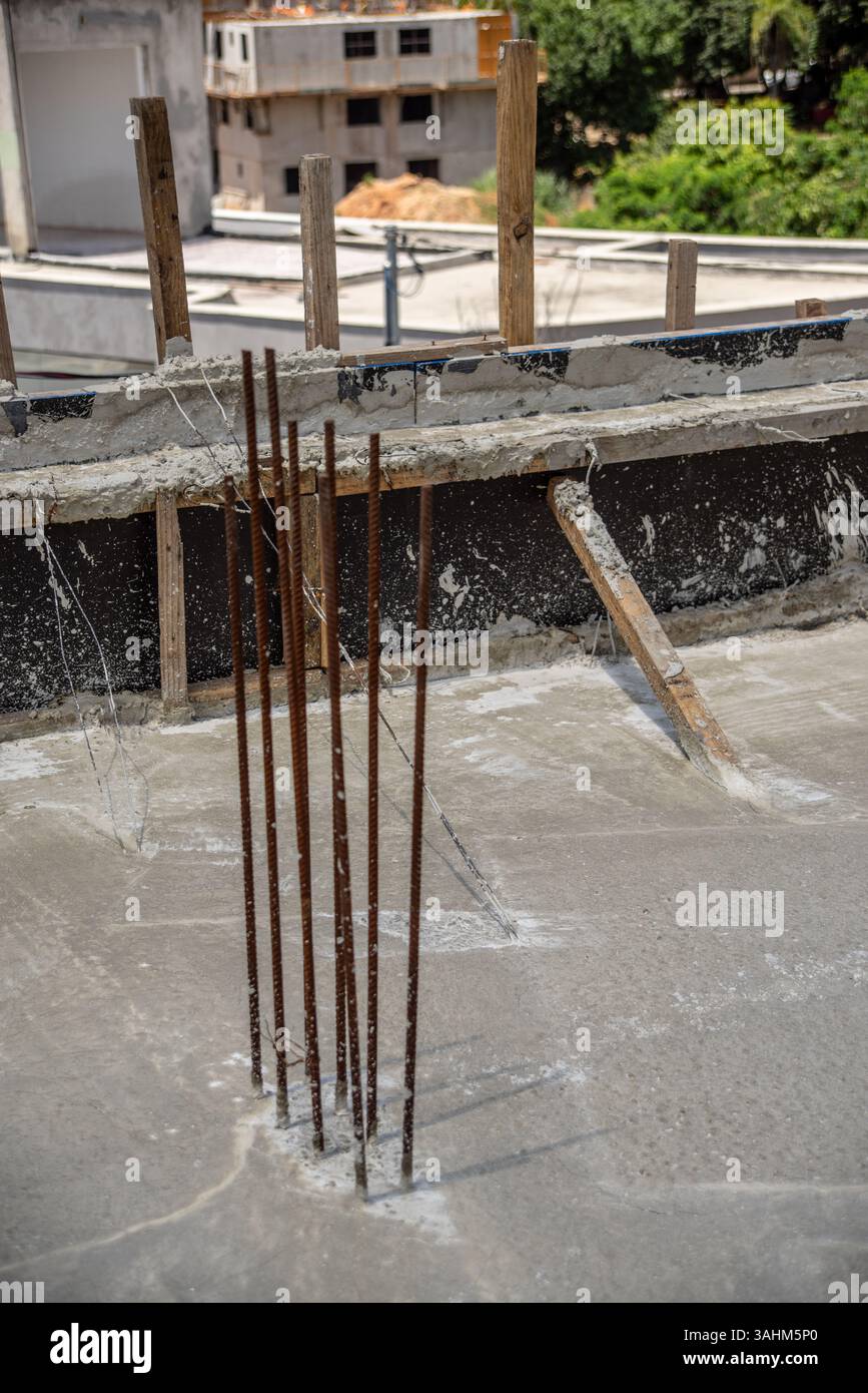 rebar (reinforcing bars) coming out of a freshly poured concrete slab ...
