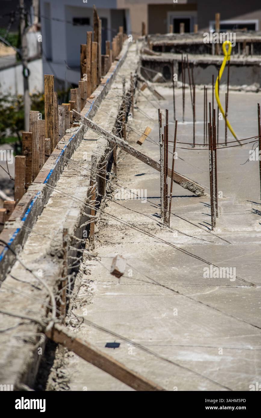 rebar (reinforcing bars) coming out of a freshly poured concrete slab ...