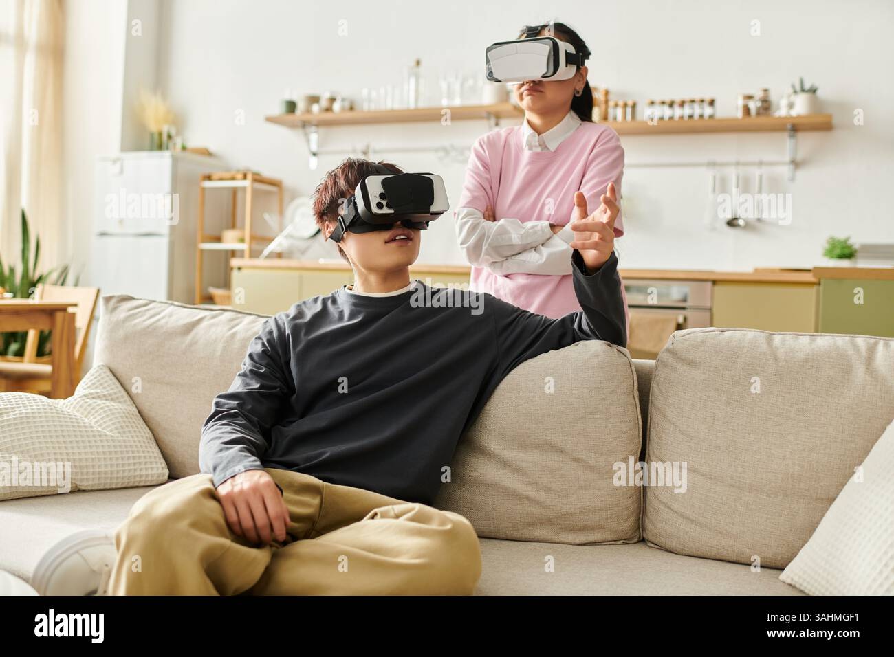 A young asian couple engages with virtual reality headsets, sharing an ...
