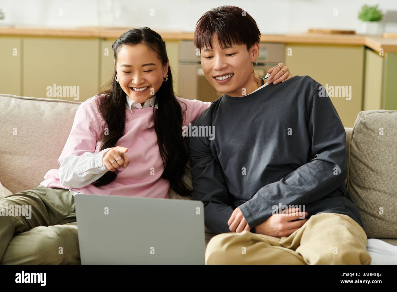Couple sits on couch watch hi-res stock photography and images - Alamy