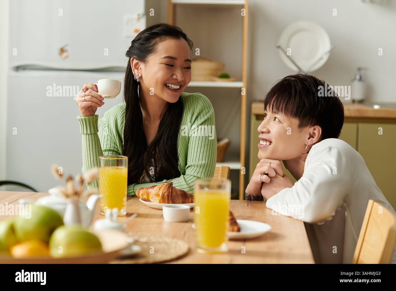 With smiles and laughter, a young couple shares a delightful breakfast ...