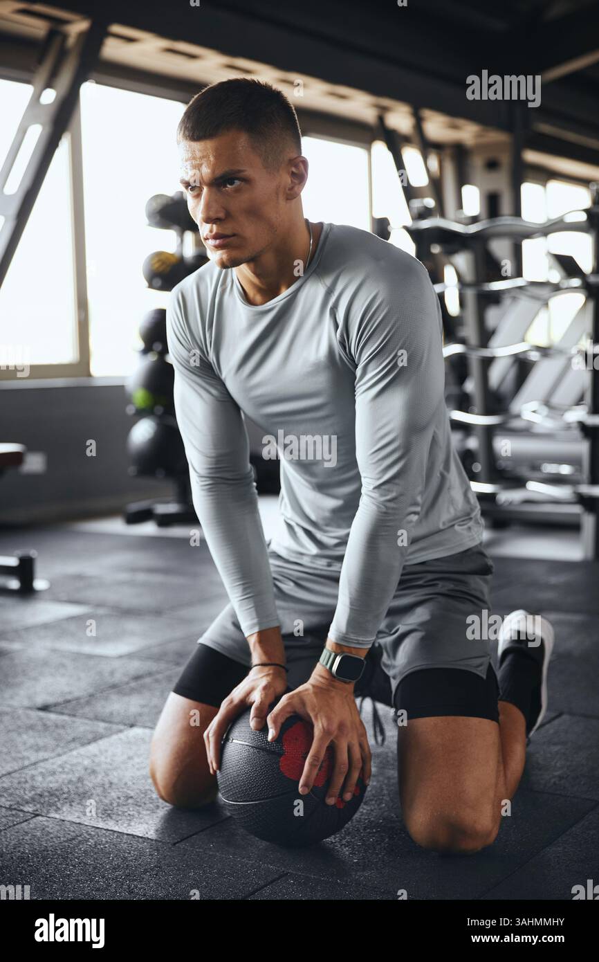 Handsome muscular man resting on knees after intense workout with ...