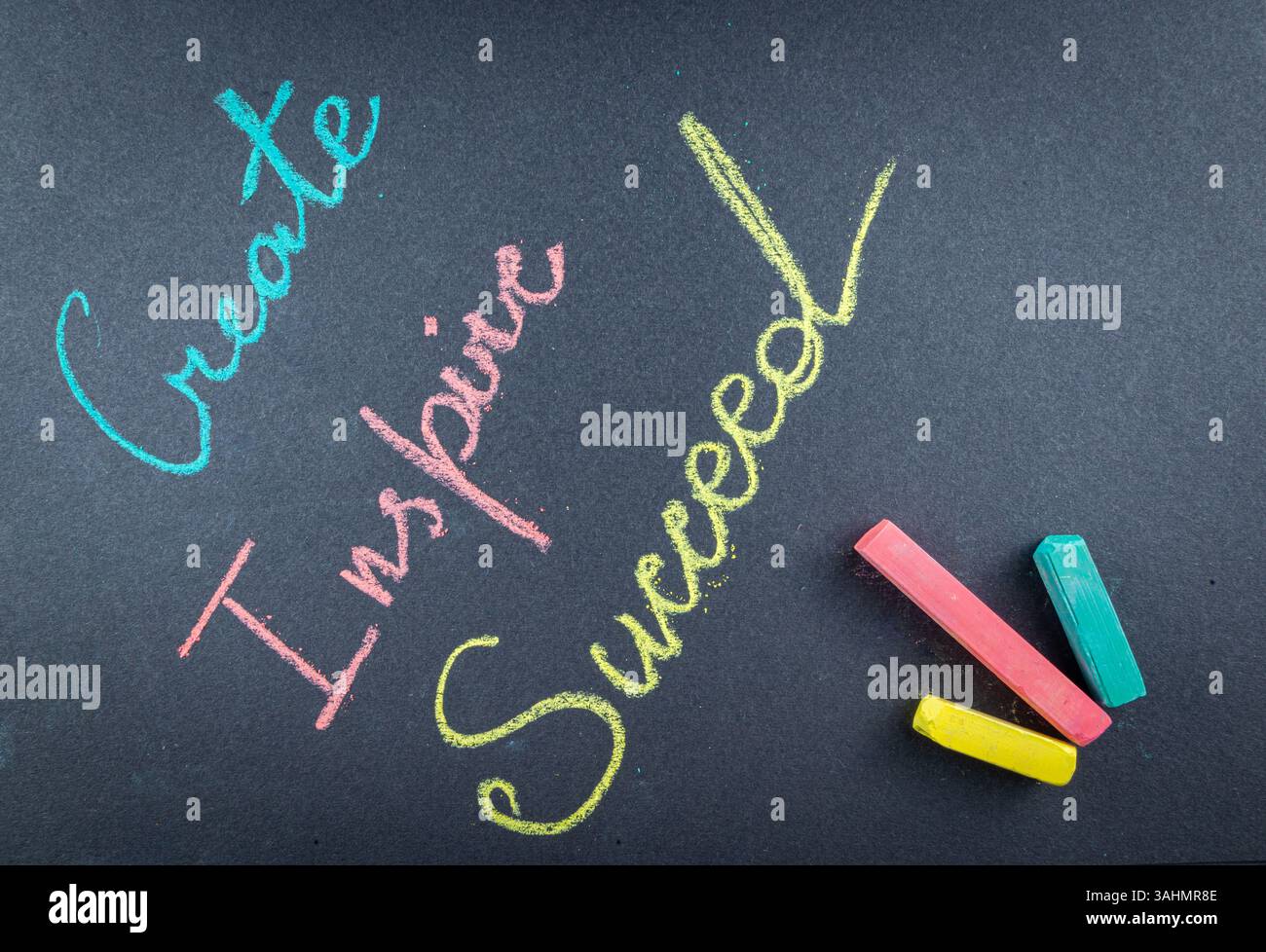 A blackboard displays the inspiring words create, inspire, and succeed ...