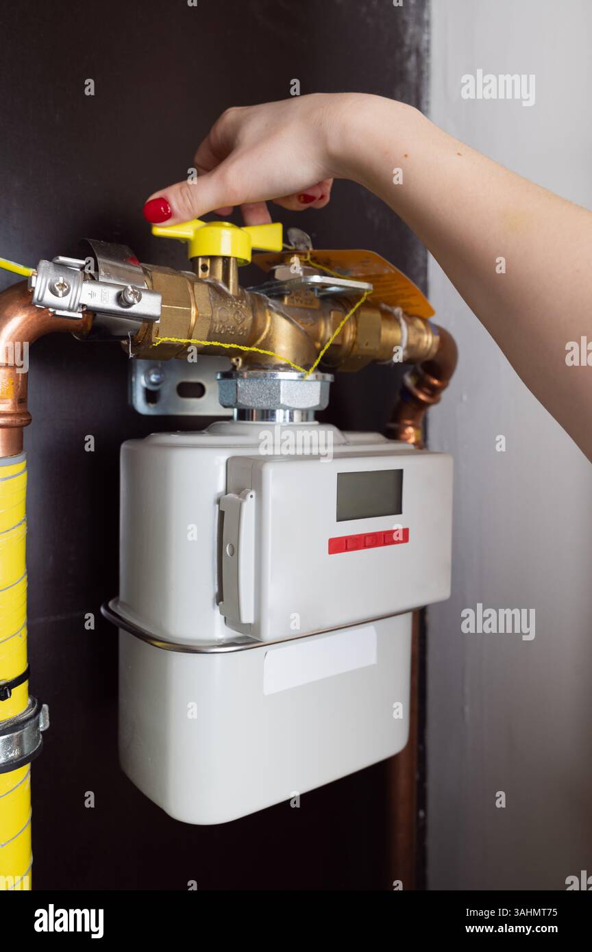 A hand skillfully operating a gas meter valve within a modern ...