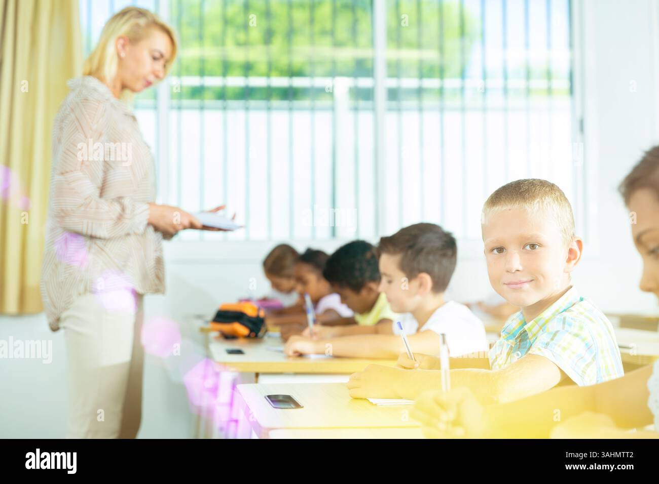 Boy sitting at desk studying in classroom Stock Photo - Alamy