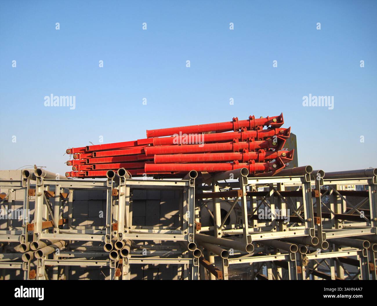 Stacked Red Steel Props and Scaffolding Frames at a Construction Site ...