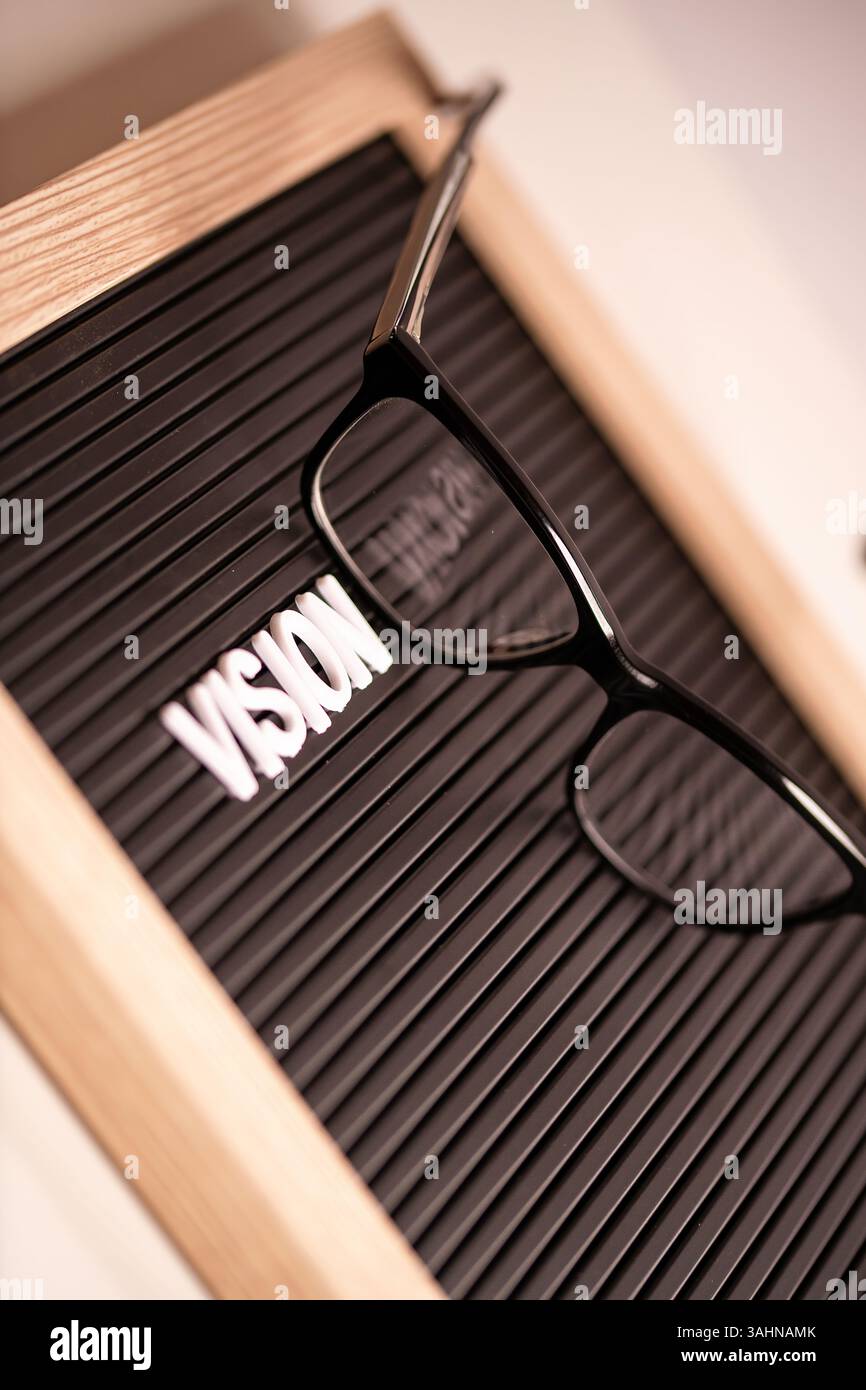 Eyeglasses placed on a letter board displaying the word “VISION ...