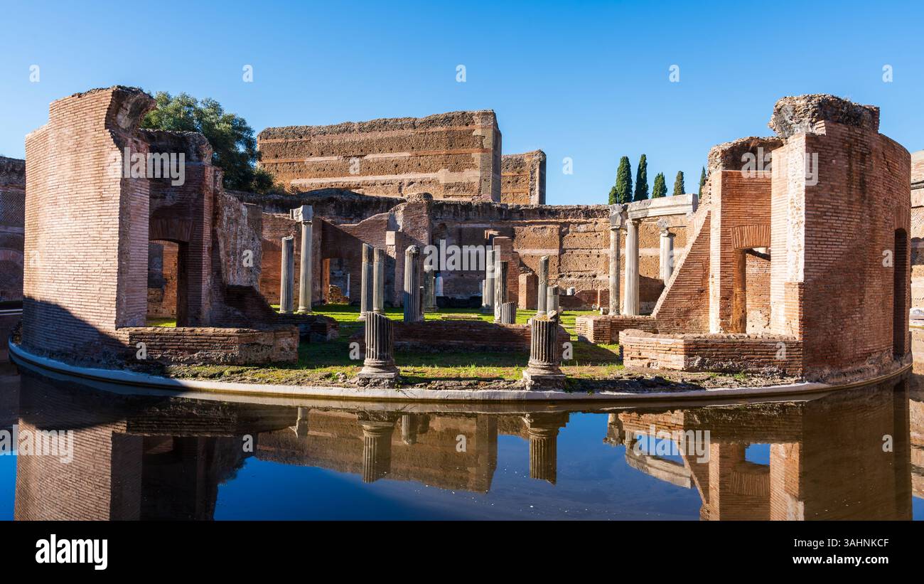 Roman ruins reflected on the water of ancient pool surrounding them ...