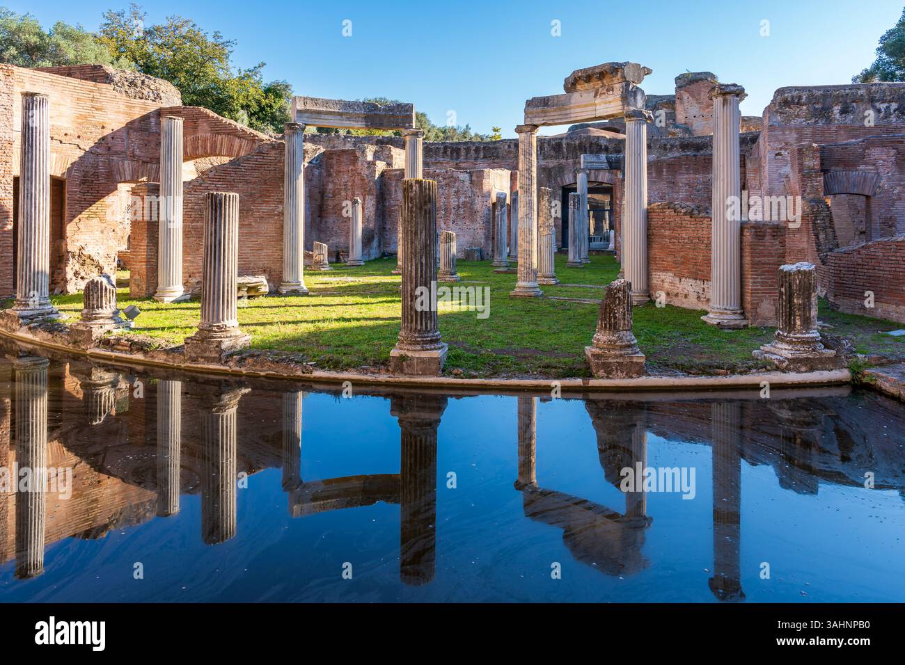 Roman ruins reflected on the water of ancient pool surrounding the ...
