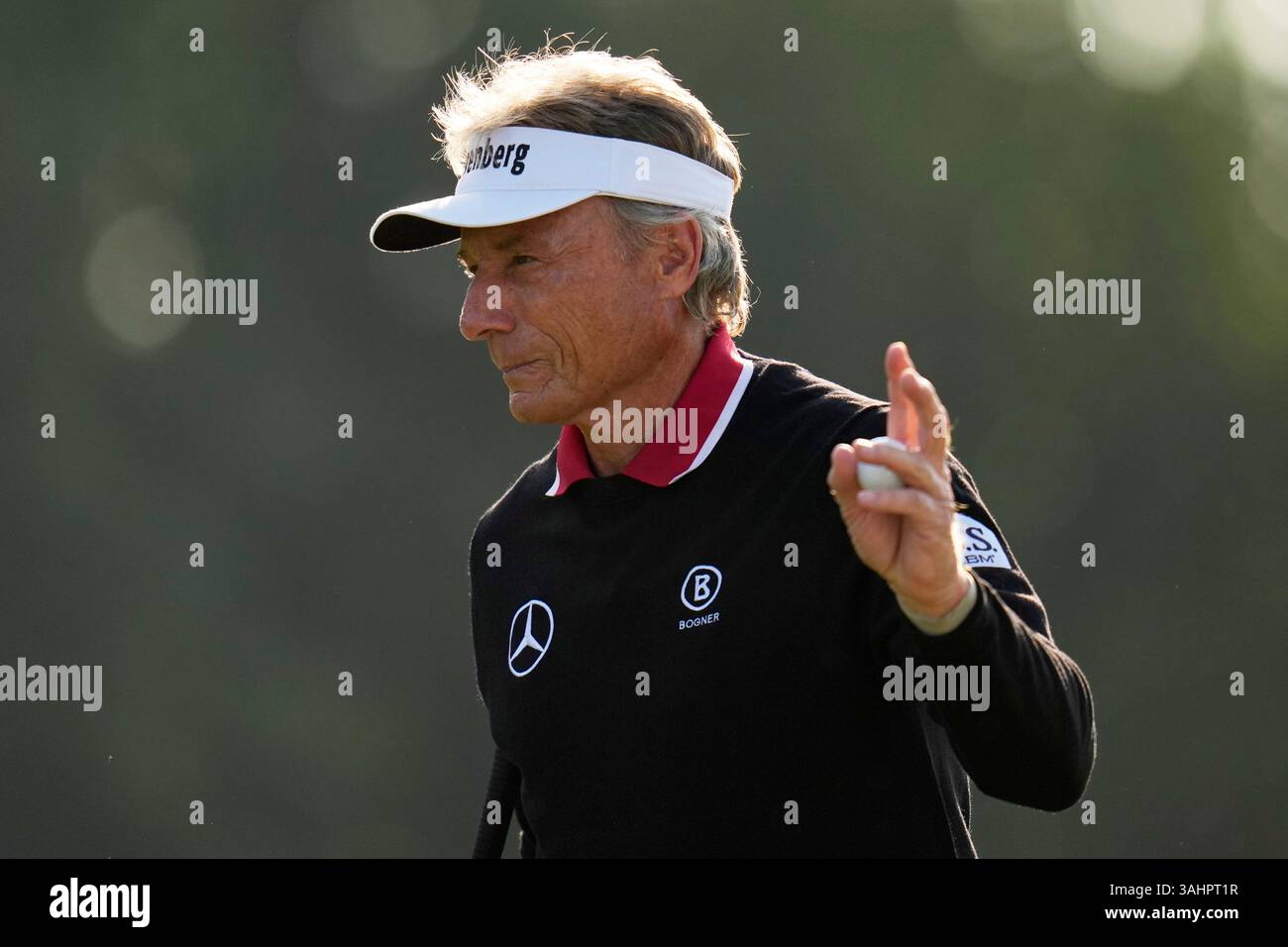 Bernhard Langer, of Germany, walks to the green on the first hole ...