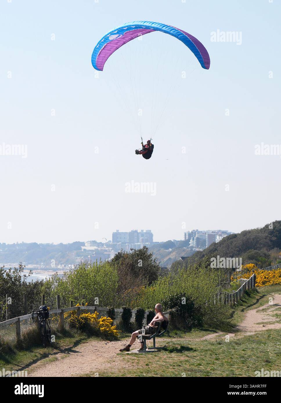A person paraglides over the cliffs above Boscombe beach in Dorset, in ...