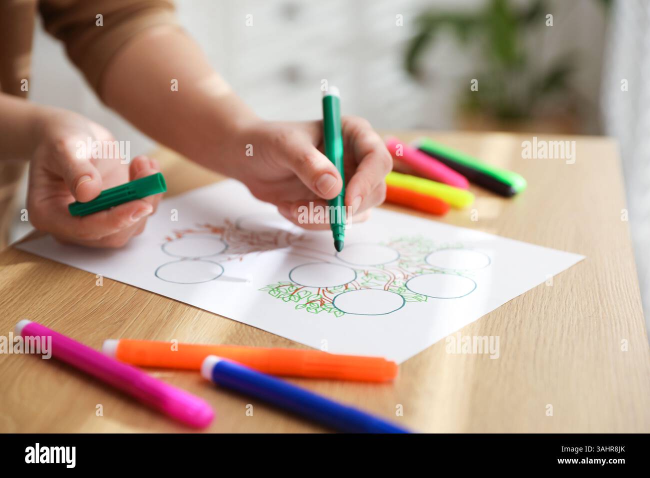 Woman drawing family tree at wooden table, closeup Stock Photo - Alamy