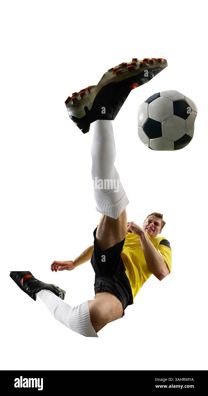 Young man, soccer player jumping into powerful kick mid-air in ...