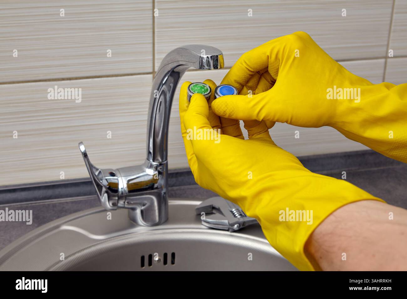 replacing a clogged faucet aerator in the kitchen sink Stock Photo - Alamy