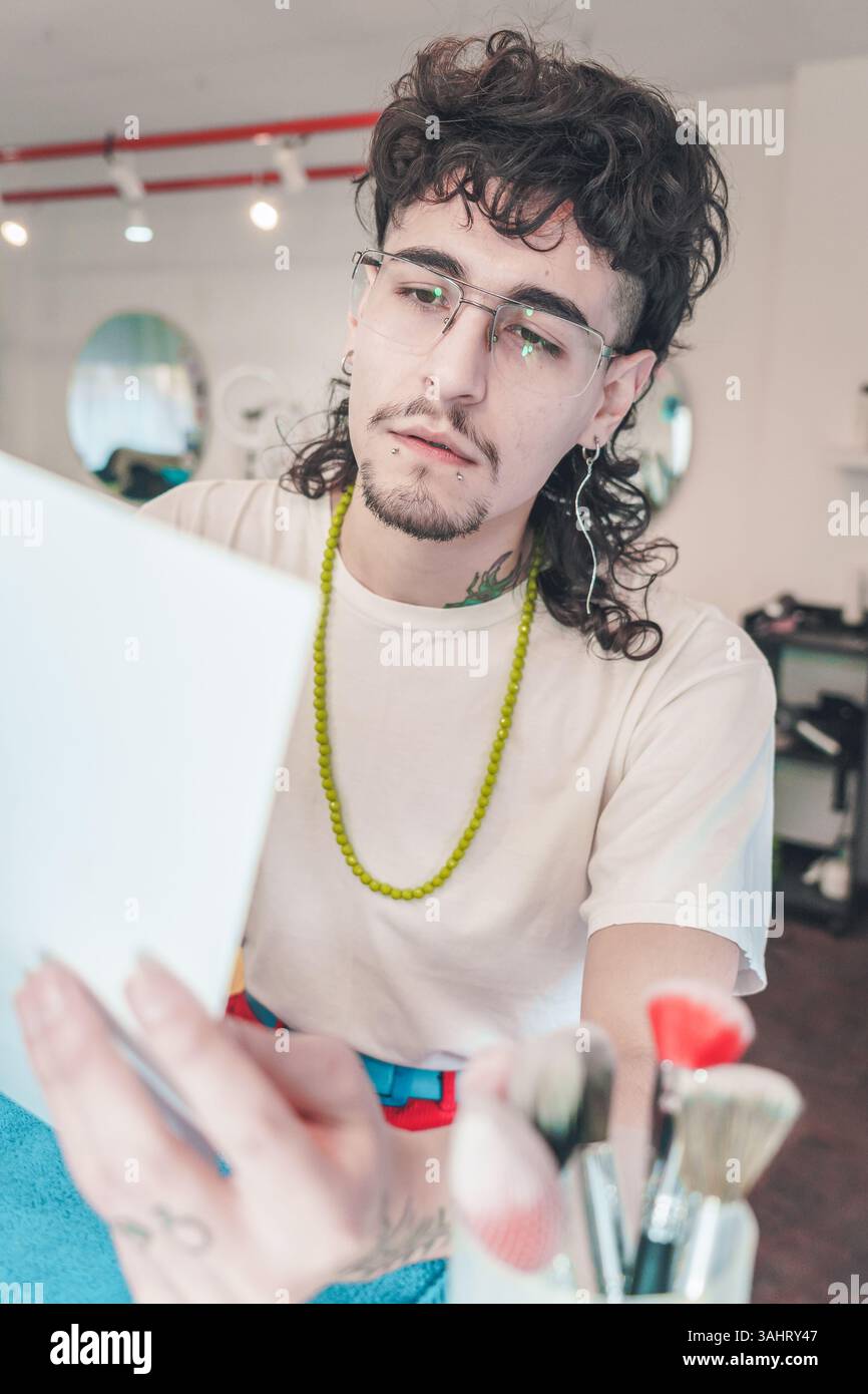 Make-up artist with a mullet haircut and glasses, wearing a green ...