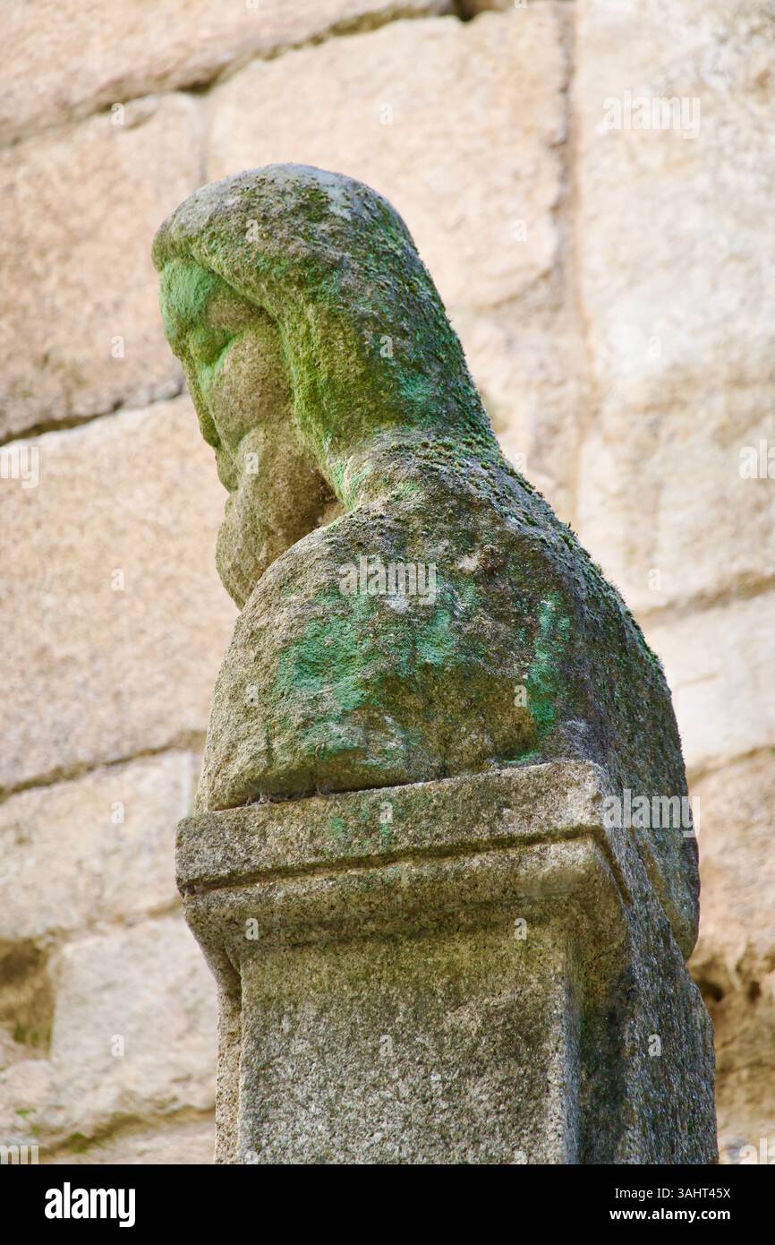 Granite stone carved bust sculpture covered in green algae of Jesus Christ on a stair plinth in ...
