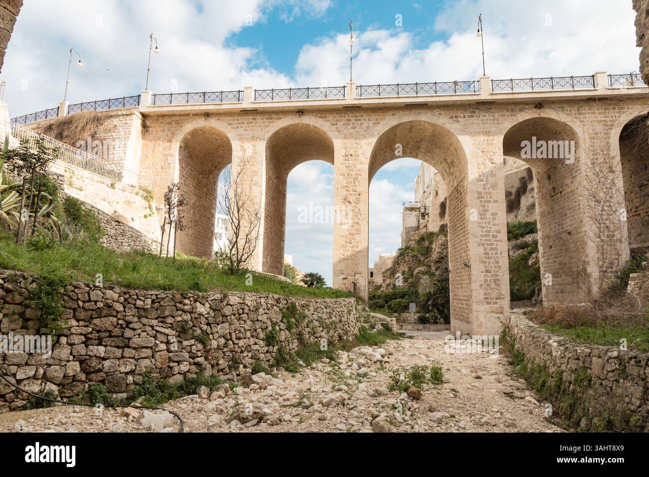 A historic stone bridge crossing over Lama Monachile beach in Polignano ...