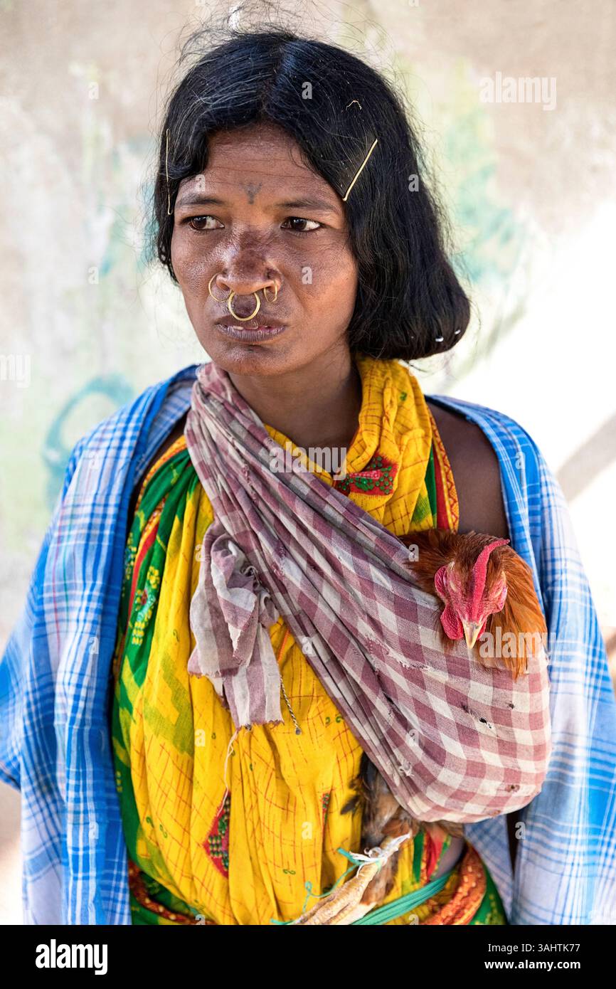 Woman holding a chicken from a Dongria Kondh tribe in Orissa in India ...