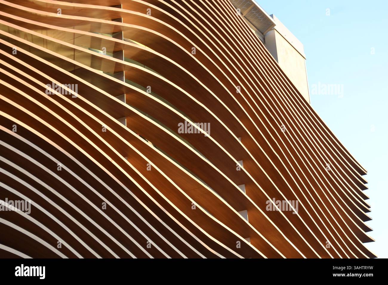 Curved long brown wooden insulation boards is curious facade decor of ...
